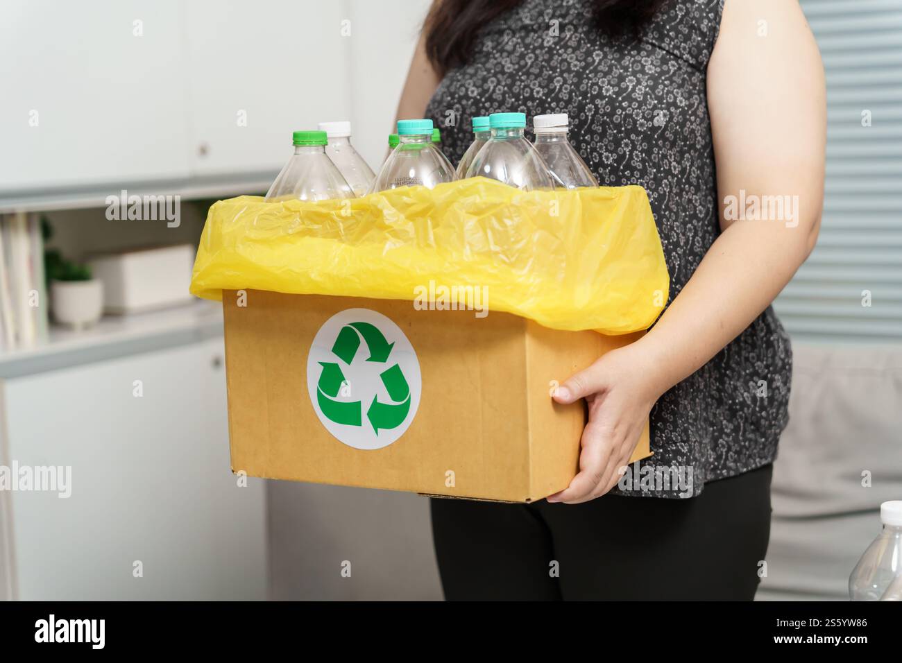 Home recycle eco green zero concept Woman throwing empty plastic bottle in recycling bin with ...