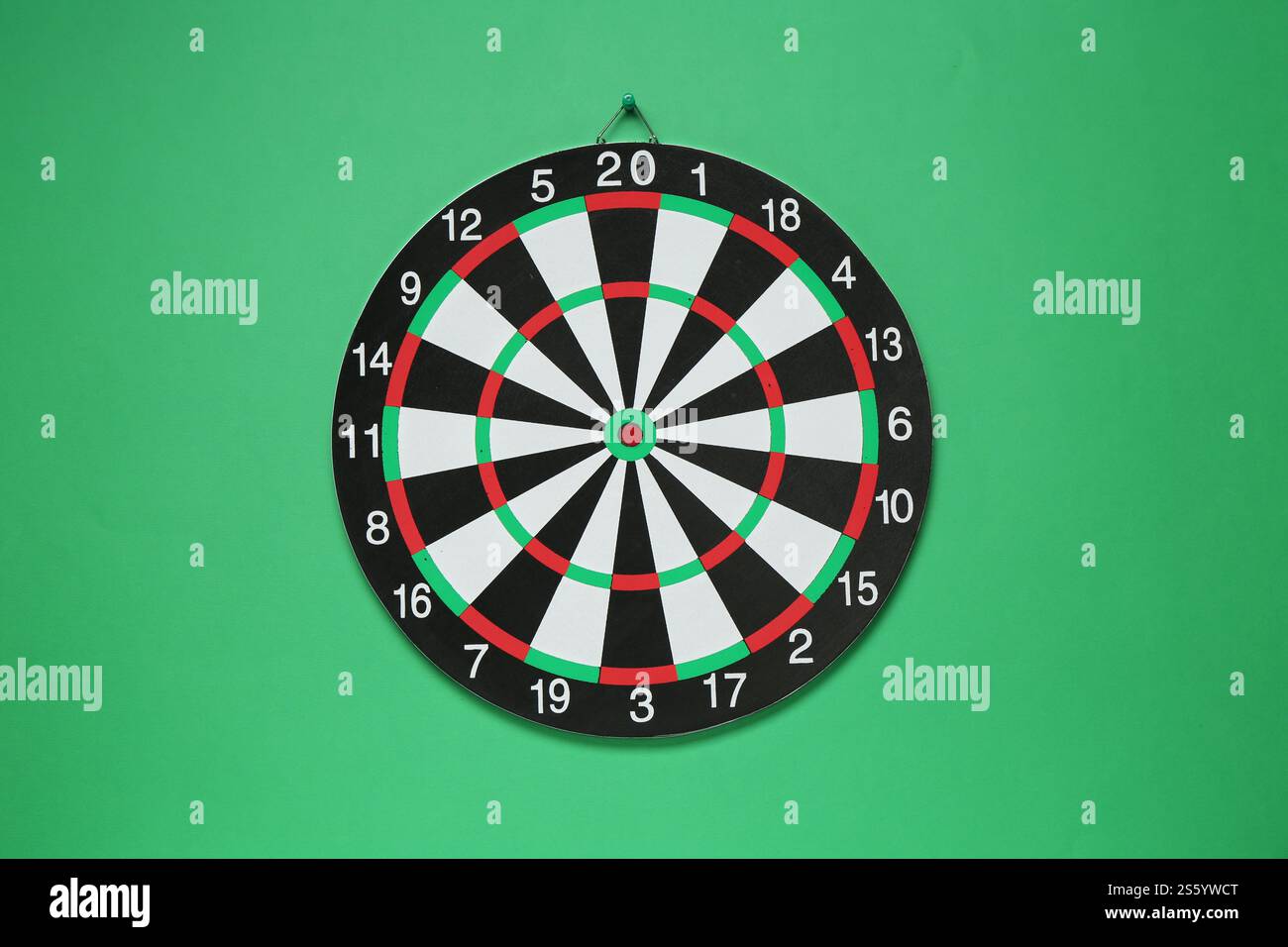 One dart board hanging on green wall Stock Photo - Alamy