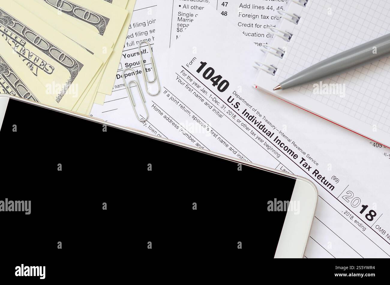 Composition of items lying on the 1040 tax form. Dollar bills, pen ...