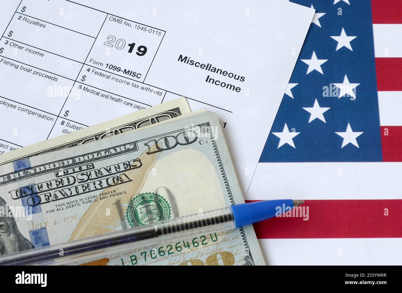 Form 1099-misc Miscellaneous income and blue pen with dollar bills lies ...