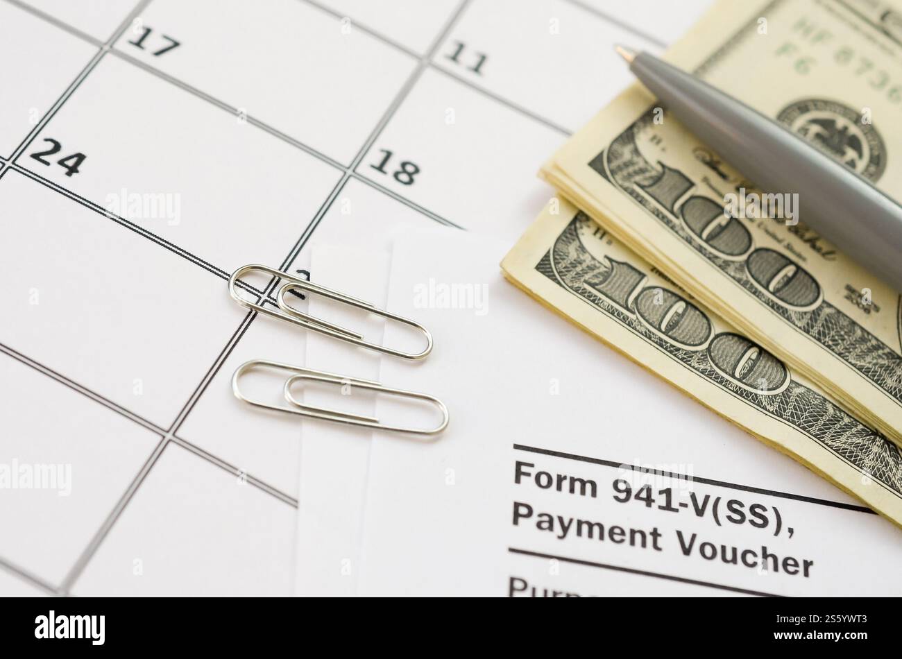 IRS Form 941-V Payment Voucher blank lies with pen and many hundred ...