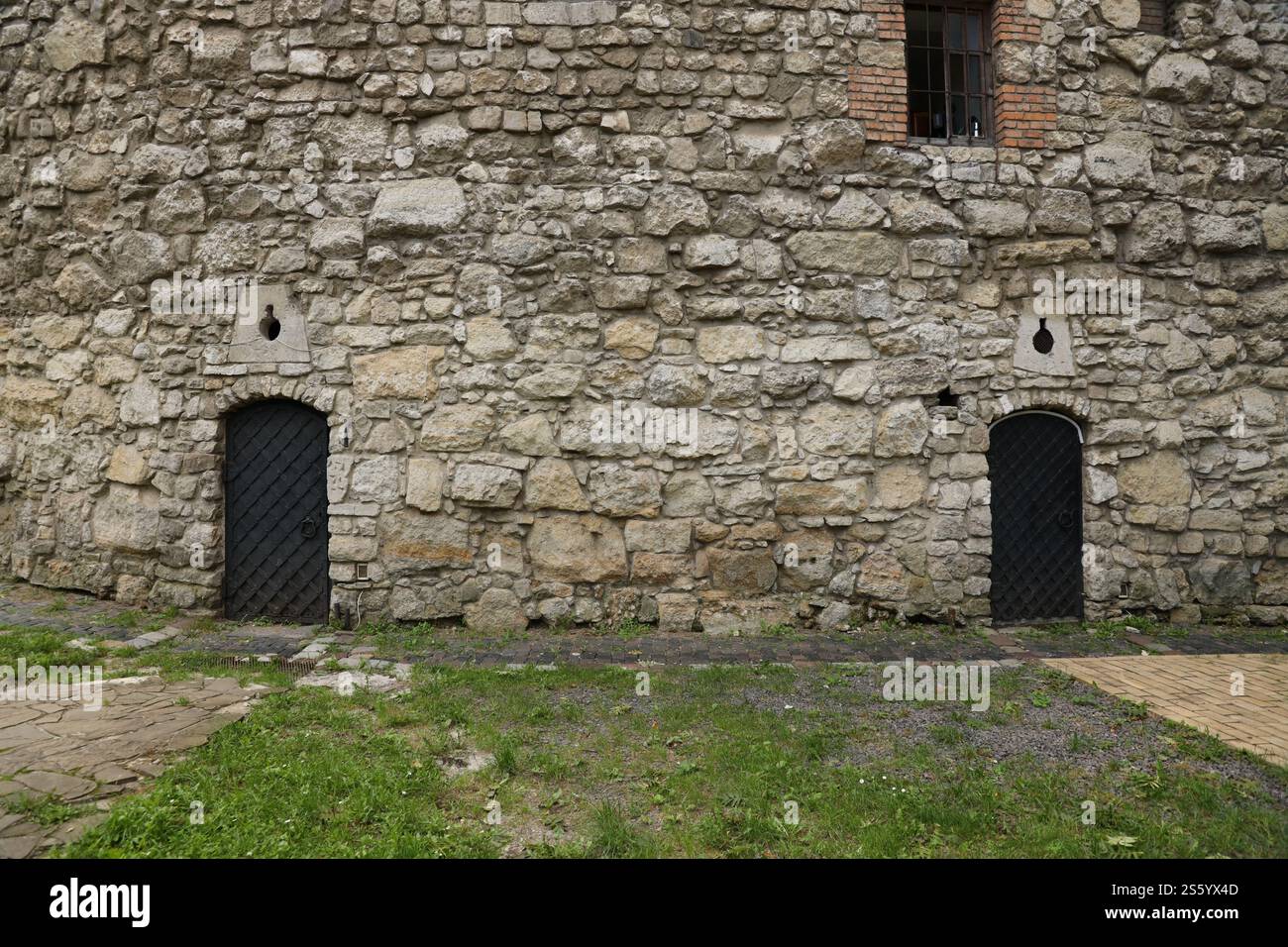 Texture of medieval stone wall and old metal door. Old castle stone wall texture background for ...
