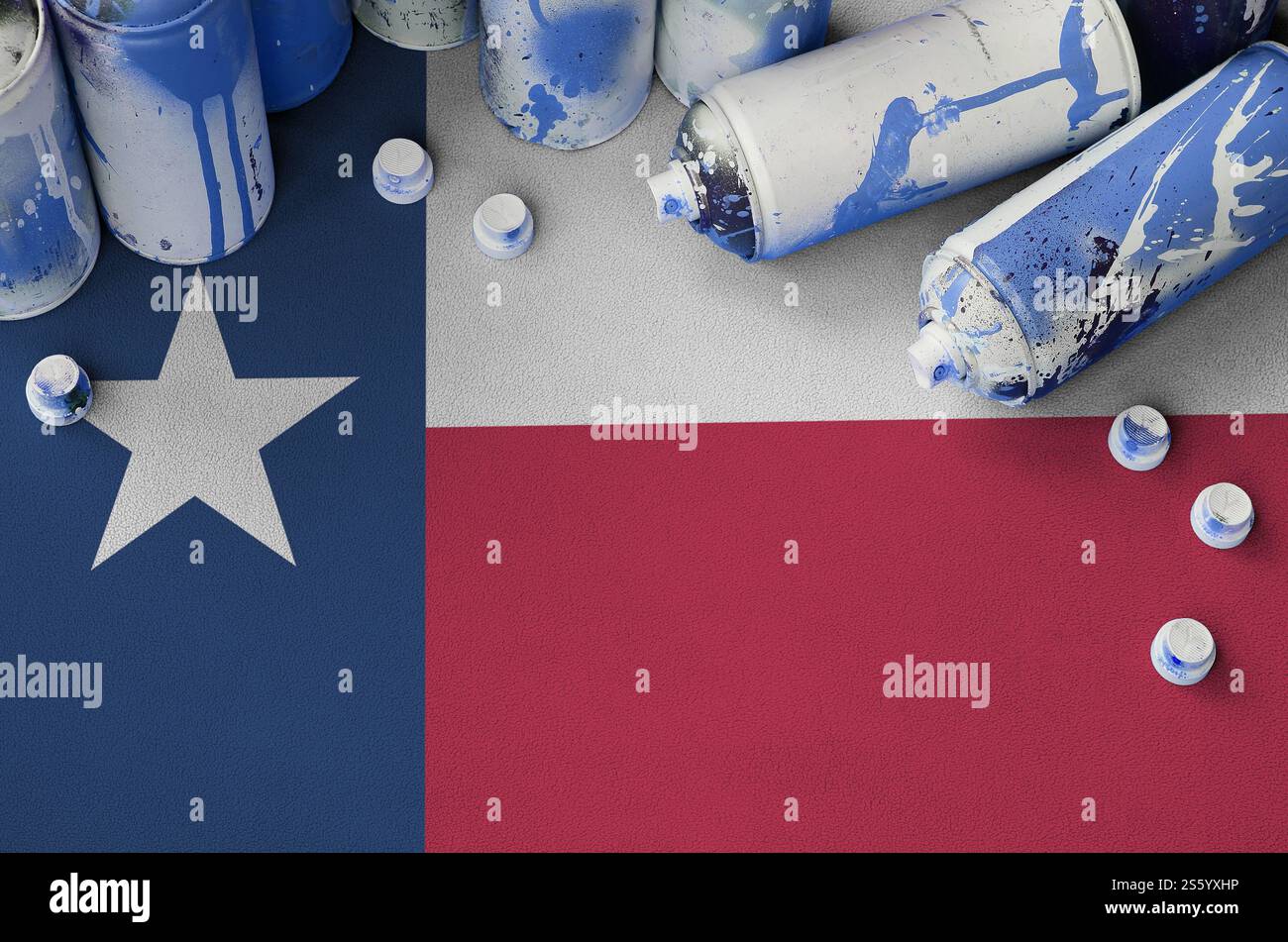 Texas US state flag and few used aerosol spray cans for graffiti ...