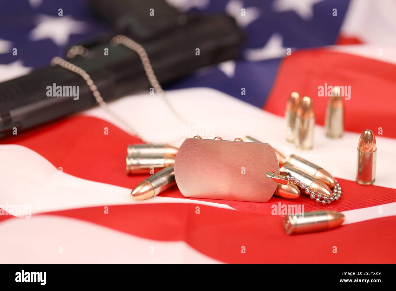 Many yellow 9mm bullets and gun with dogtags on United States flag ...