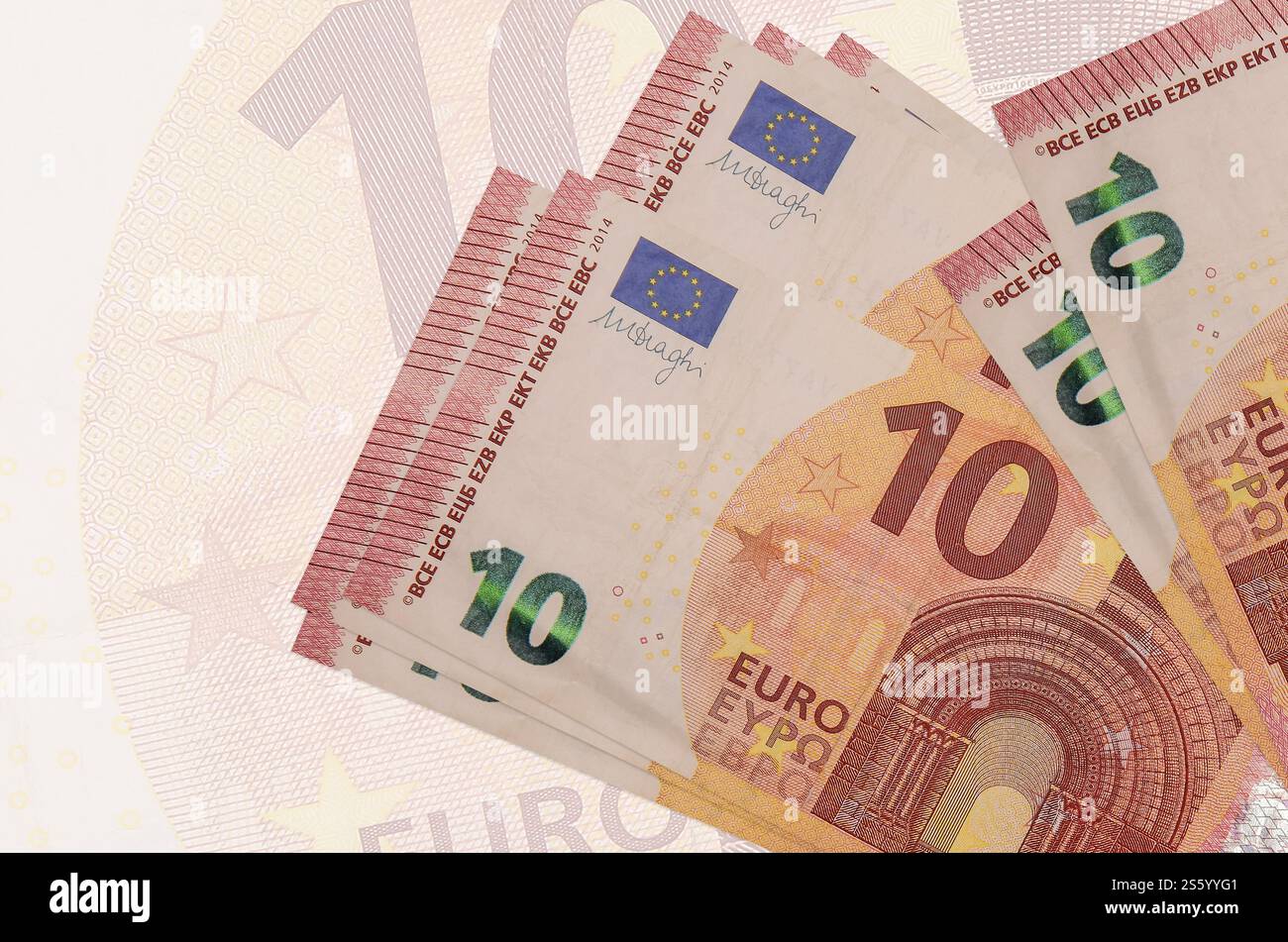 10 euro bills lies in stack on background of big semi-transparent banknote. Abstract ...