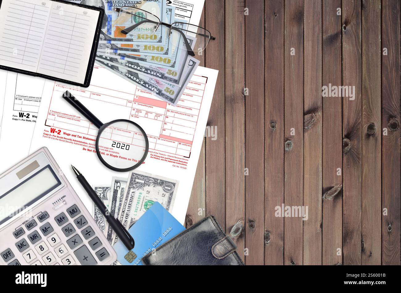 IRS form W-2 wage and tax statement lies on flat lay office table and ...