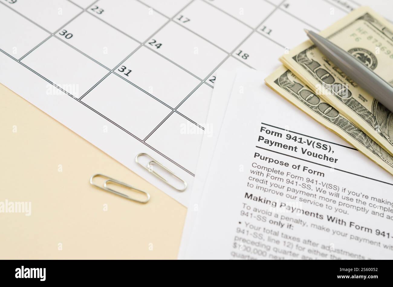 IRS Form 941-V Payment Voucher blank lies with pen and many hundred ...