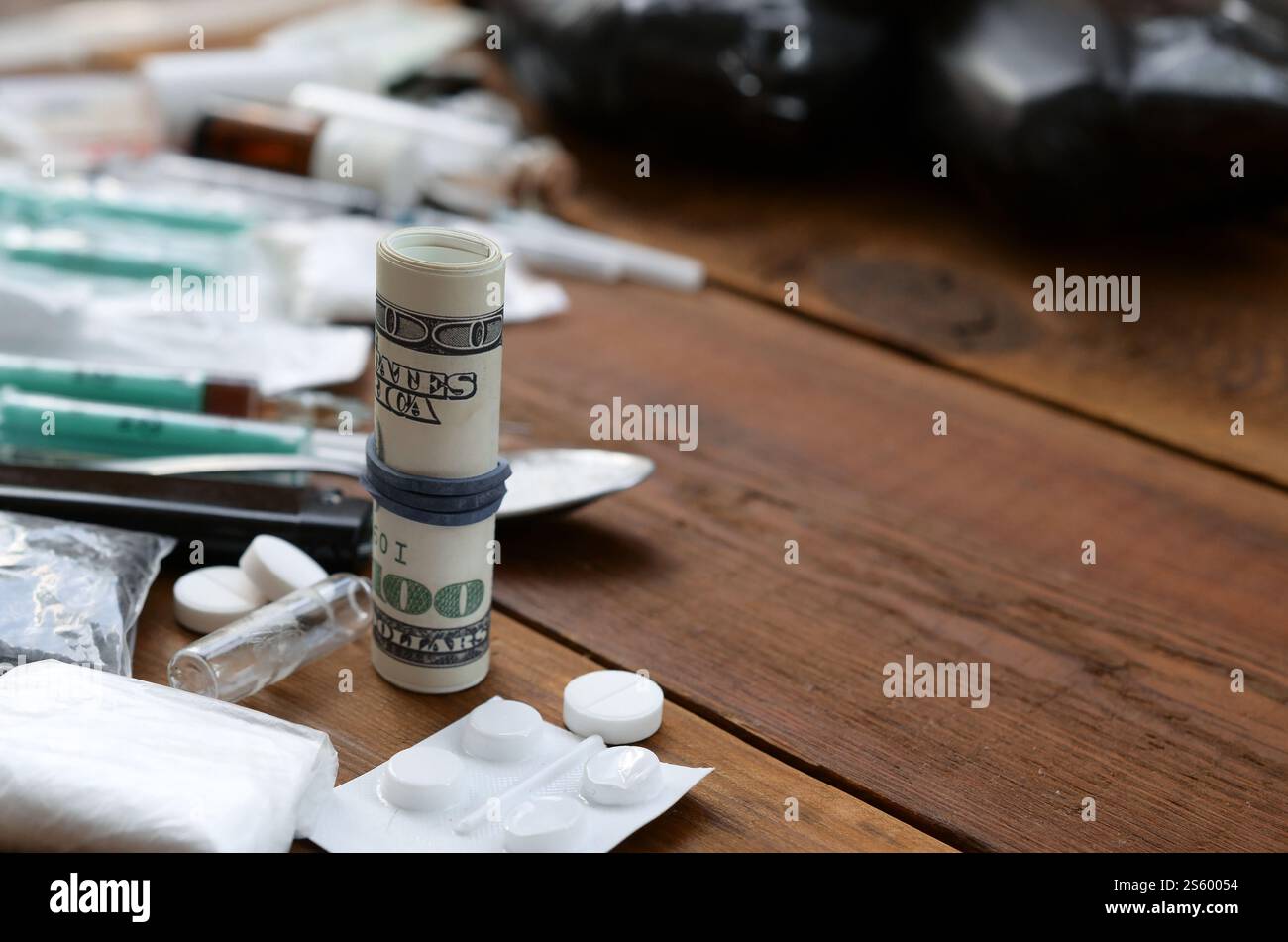 Roll of hundred dollar bills on background of narcotic drug dealer ...
