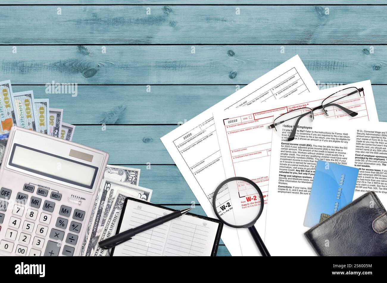 IRS form W-2 wage and tax statement lies on flat lay office table and ...