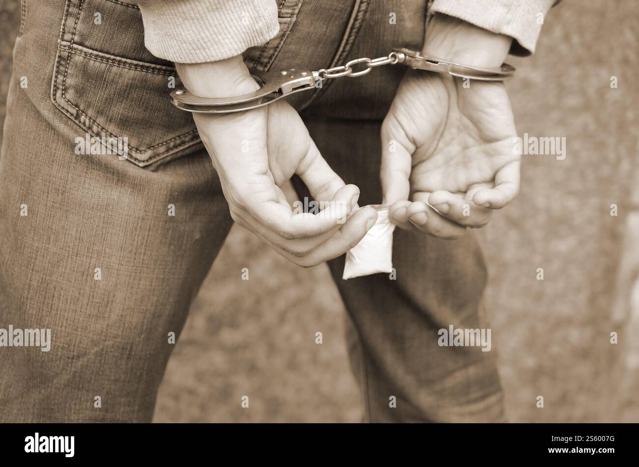 Arrested drug dealer in handcuffs with small heroin drug package on ...