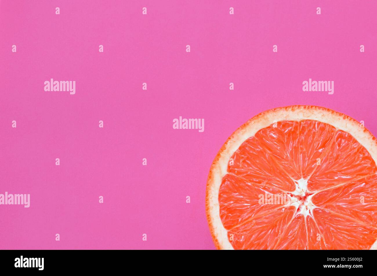 Top view of an one grapefruit slice on bright background in purple ...