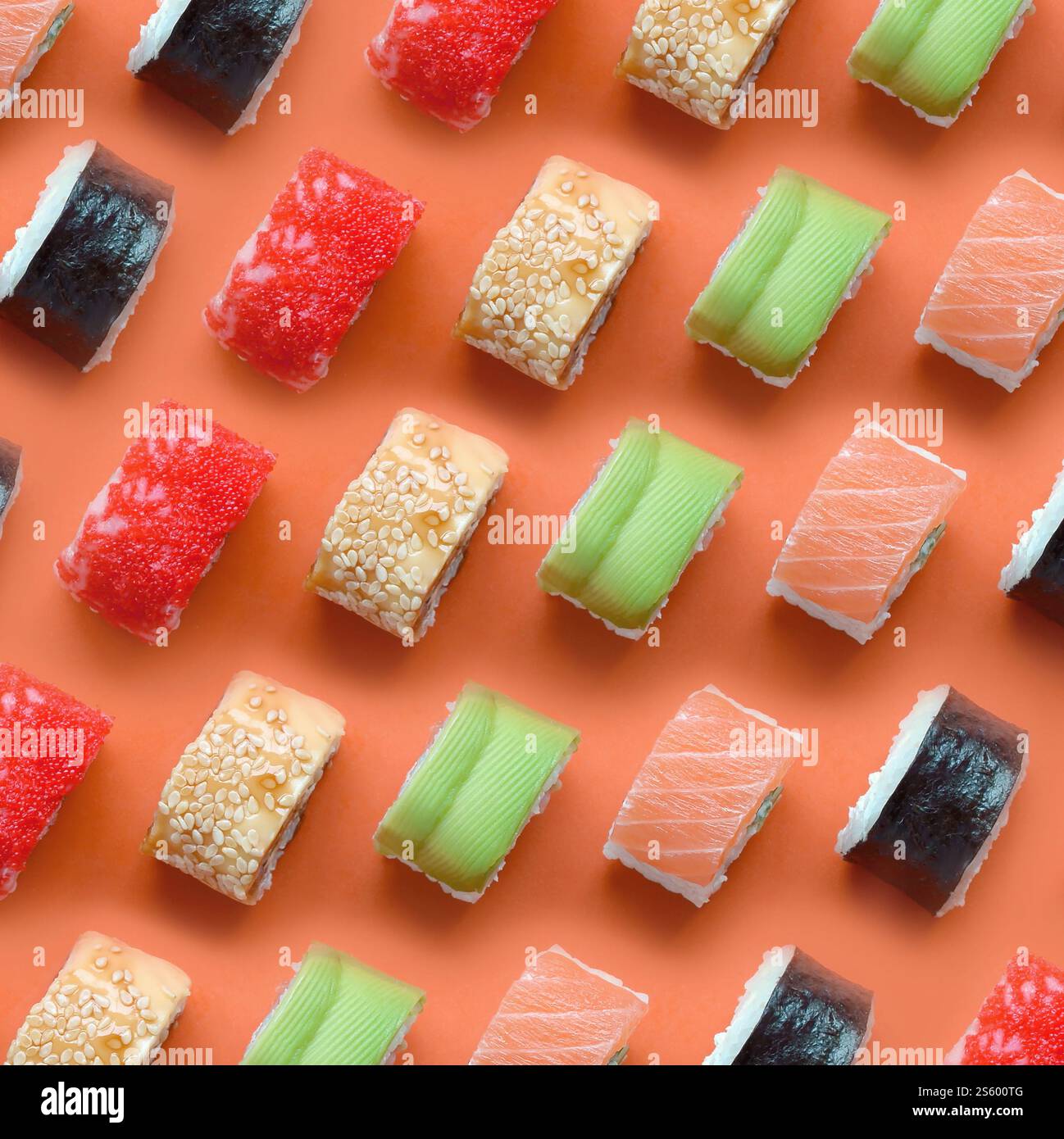 Different types of asian sushi rolls on orange background close up ...