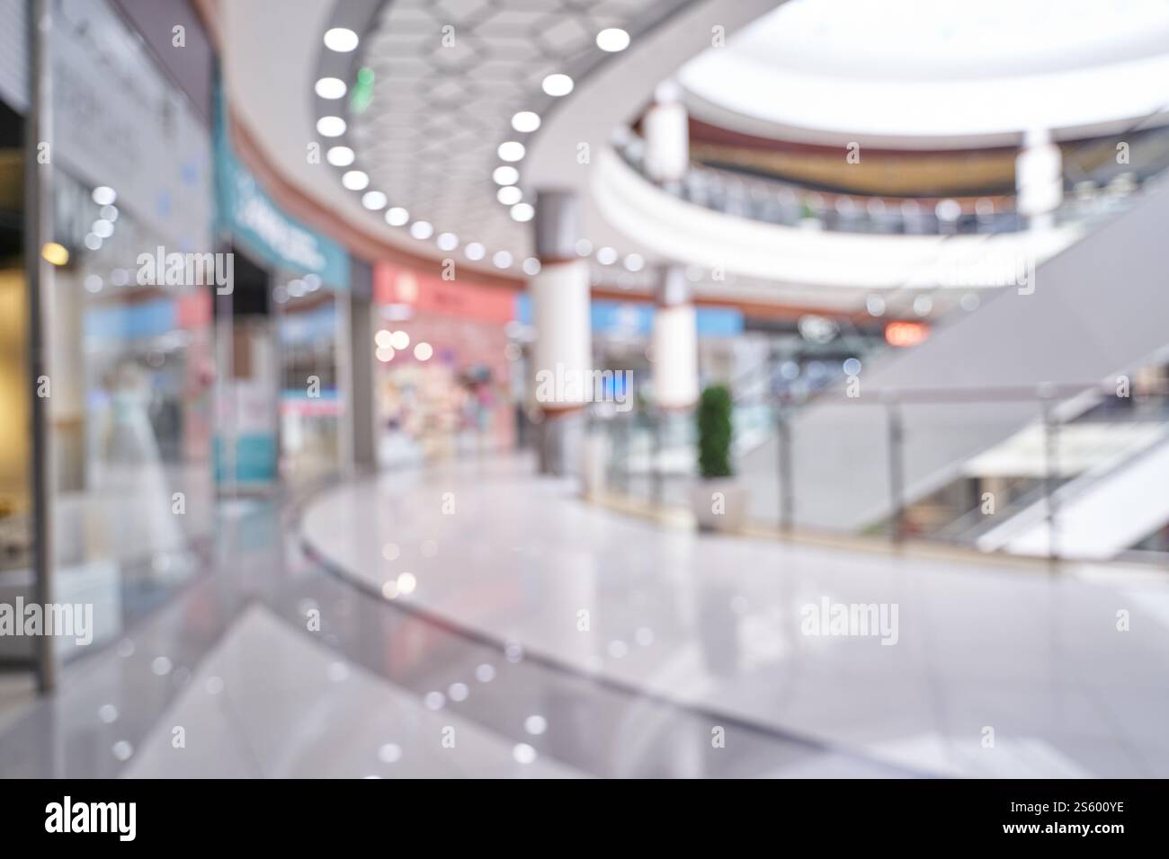 Modern shopping mall interior with blurred storefronts and elegant ...