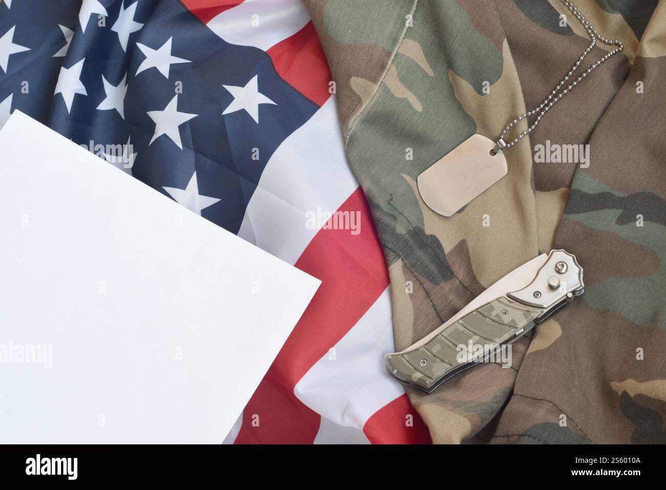 Army dog tag token and knife lies on Old Camouflage uniform and folded ...