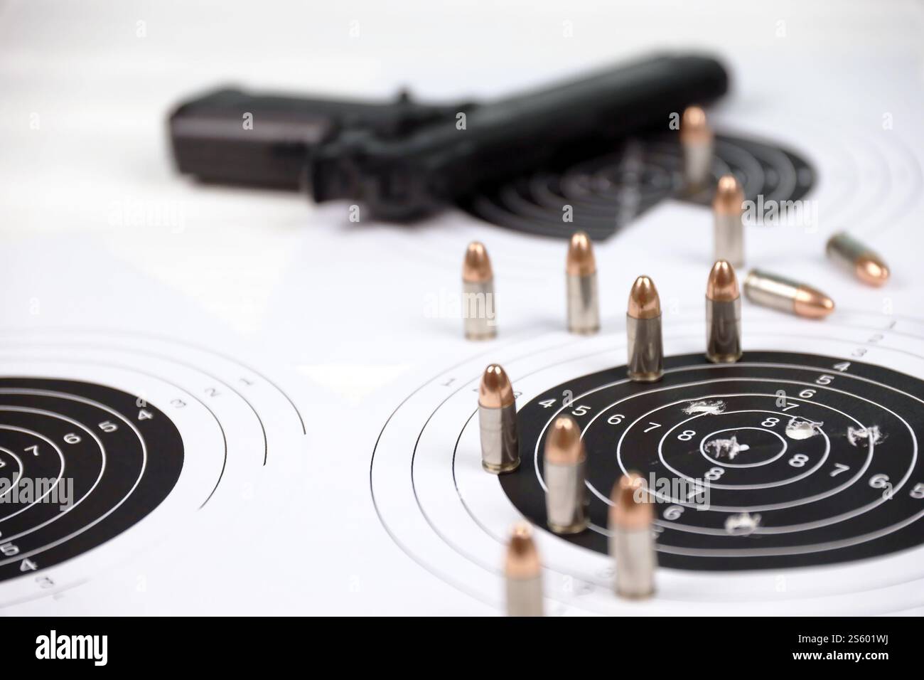 Gun and many bullets shooting targets on white table in shooting range ...