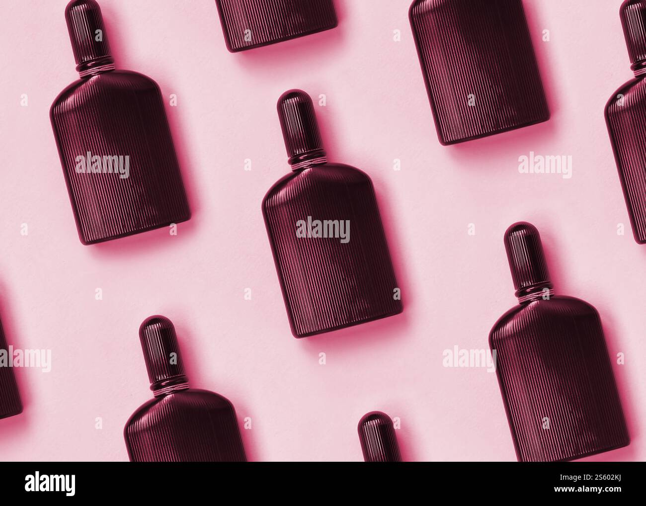 Dark purple perfume bottle with golden ribbon on pastel paper ...