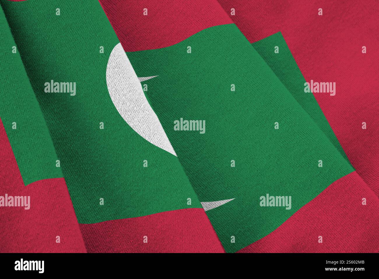 Maldives flag with big folds waving close up under the studio light ...