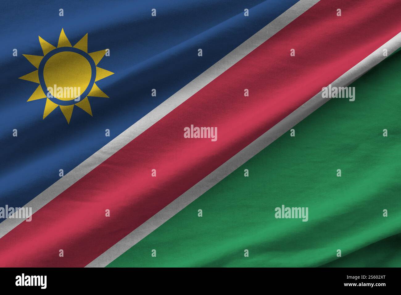 Namibia flag with big folds waving close up under the studio light ...