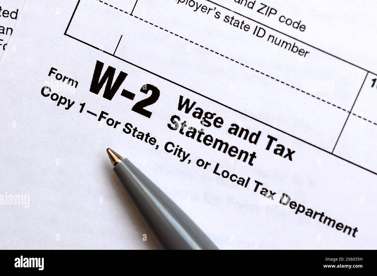 The pen lies on the tax form W-2 Wage and Tax Statement. The time to ...