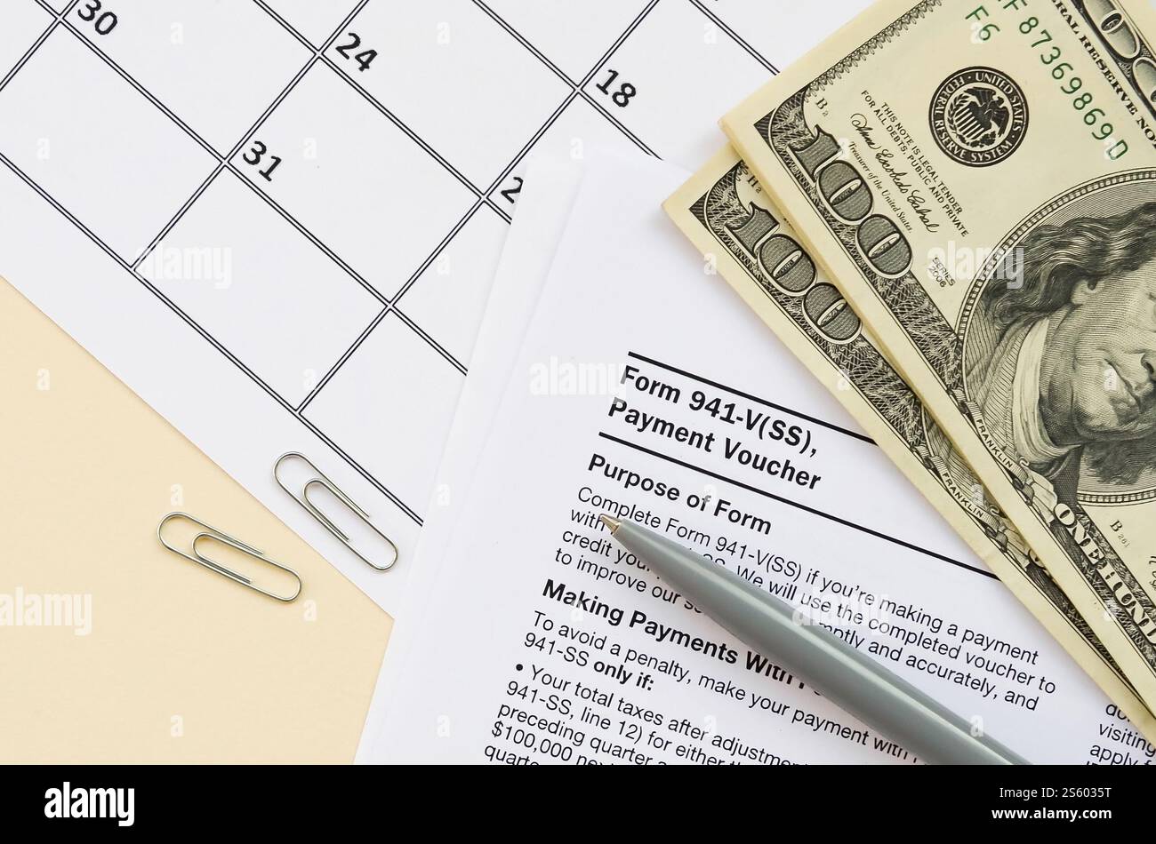 IRS Form 941-V Payment Voucher blank lies with pen and many hundred ...