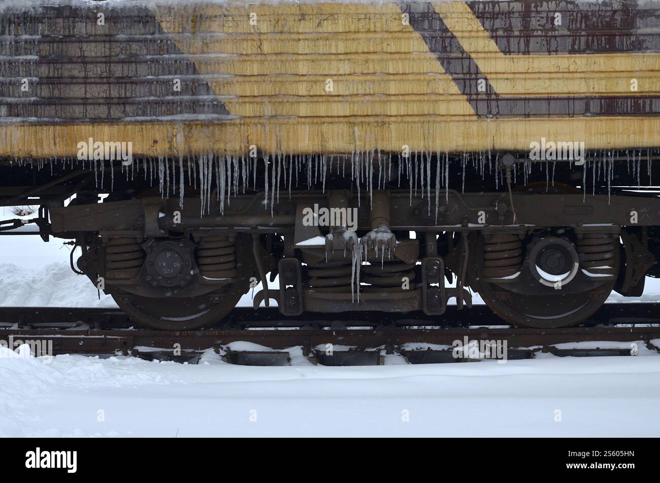 Detailed photo of a frozen car passenger train with icicles and ice on ...