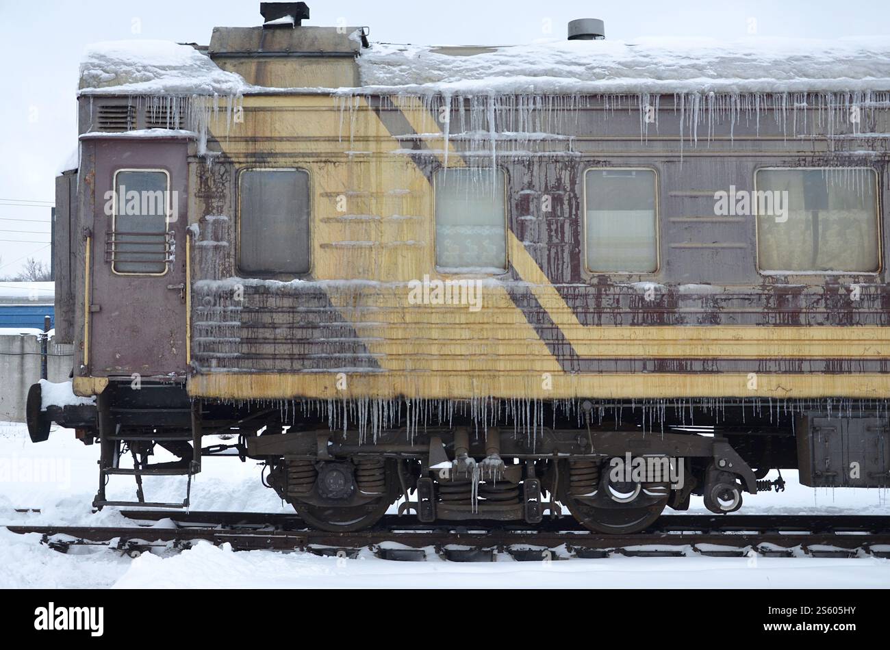 Detailed photo of a frozen car passenger train with icicles and ice on ...