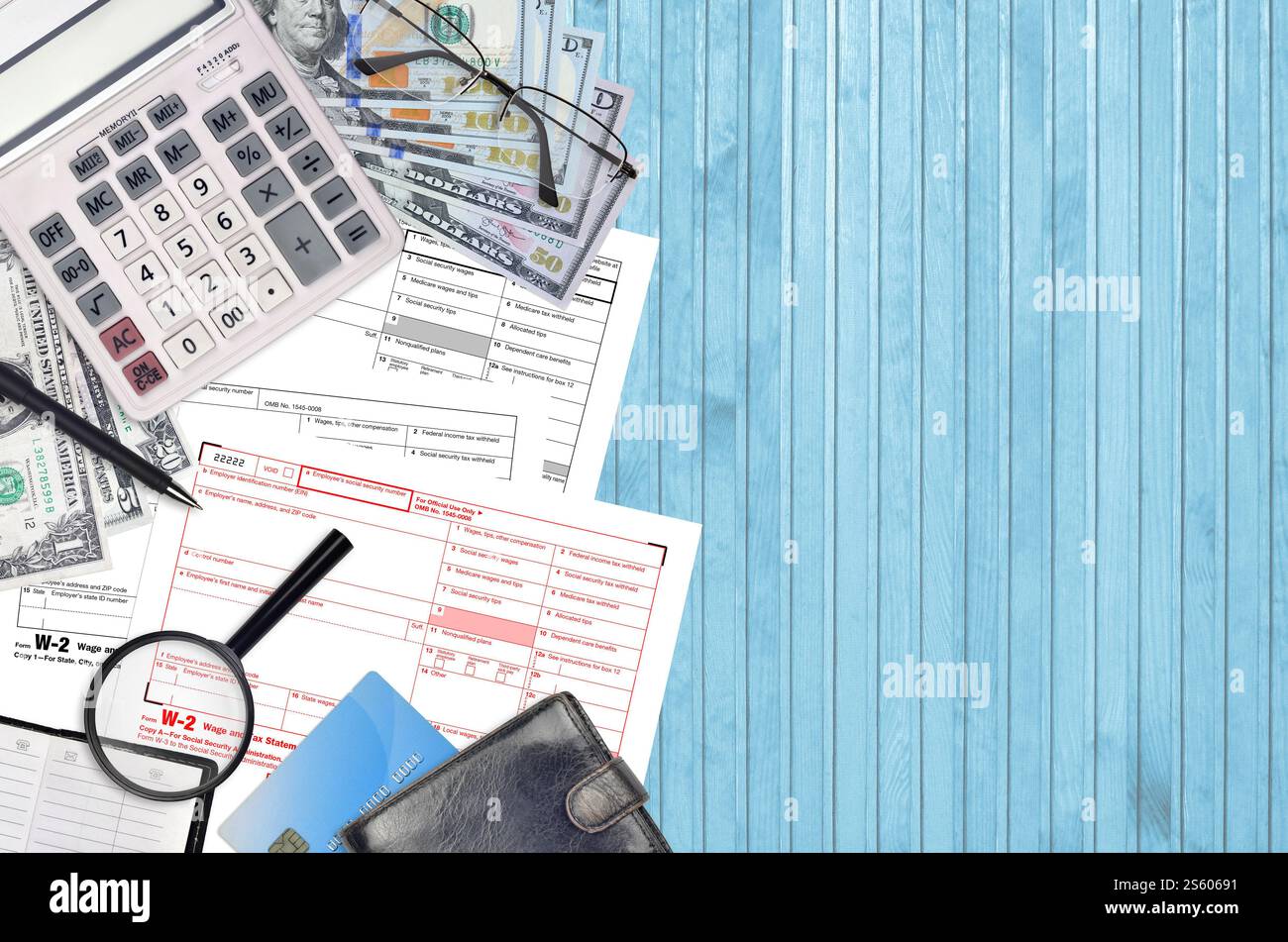 IRS form W-2 wage and tax statement lies on flat lay office table and ...