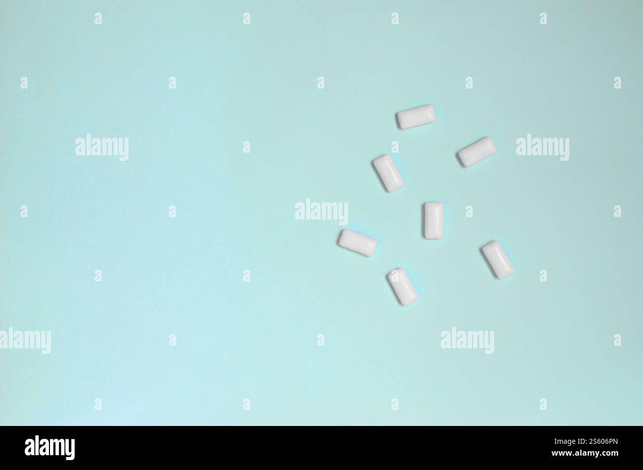 A few chewing gums lie on texture background of fashion pastel blue ...