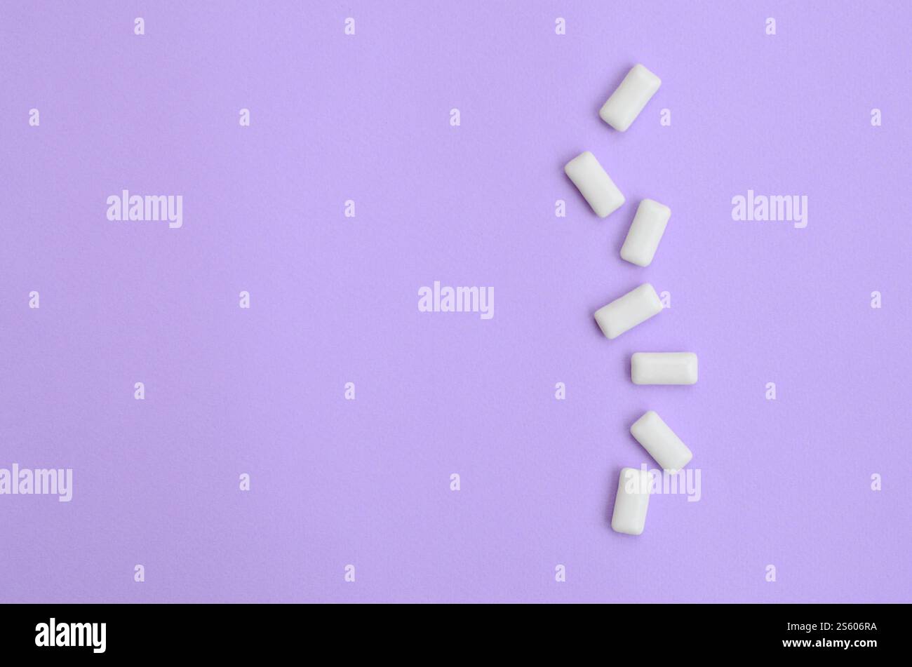 A few chewing gums lie on texture background of fashion pastel violet ...
