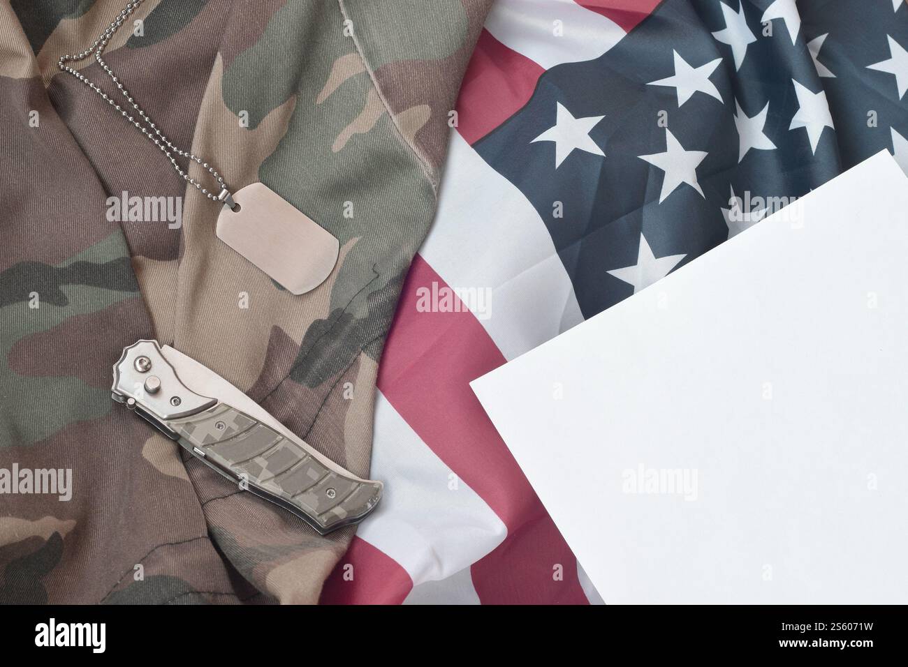 Army dog tag token and knife lies on Old Camouflage uniform and folded ...