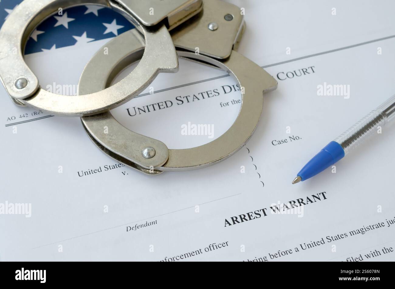 District Court Arrest Warrant court papers with handcuffs and blue pen ...