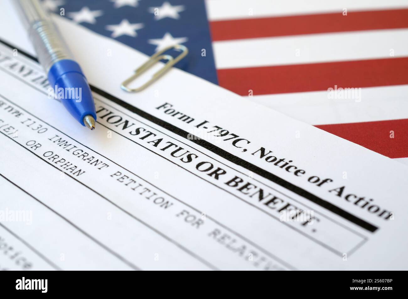 I-797c Notice of action blank form lies on United States flag with blue ...
