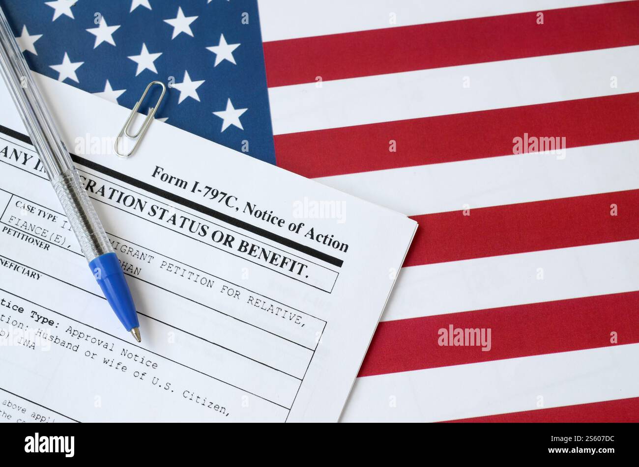 I-797c Notice of action blank form lies on United States flag with blue ...