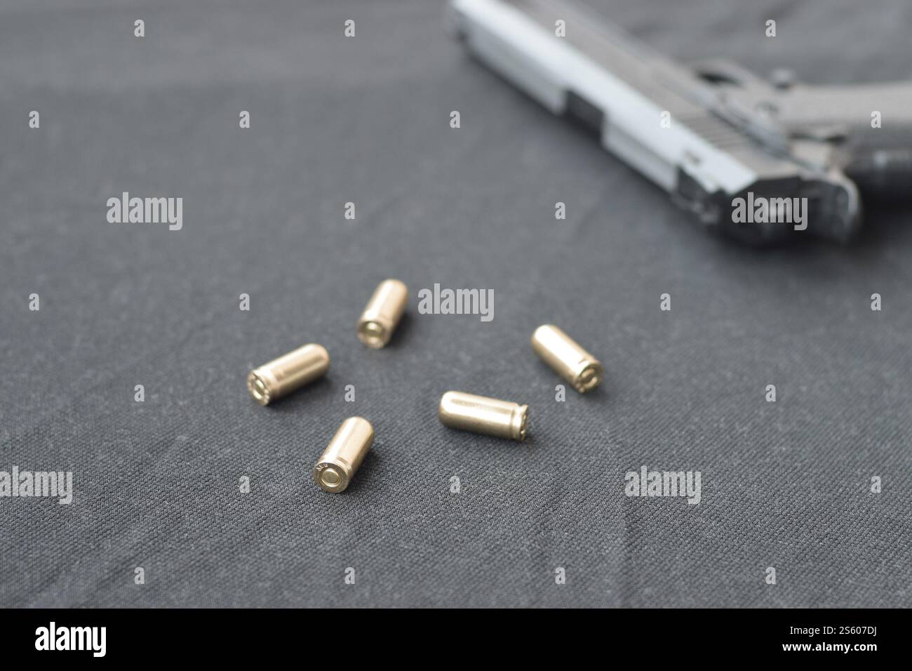 9mm bullets and pistol lie on a black fabric. A set shooting range ...
