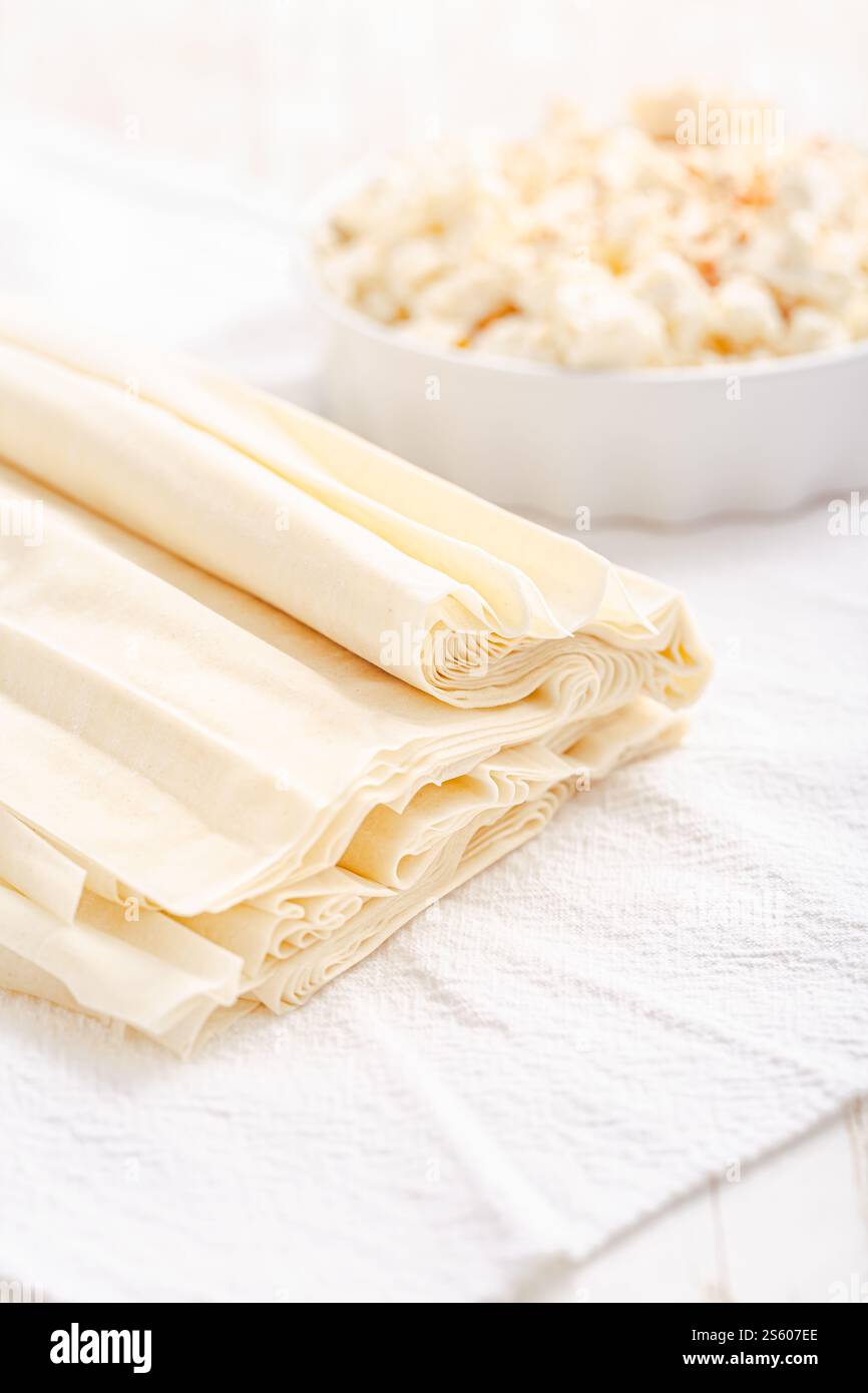 Raw phyllo dough with feta cheese, prepared for filling, making savory ...