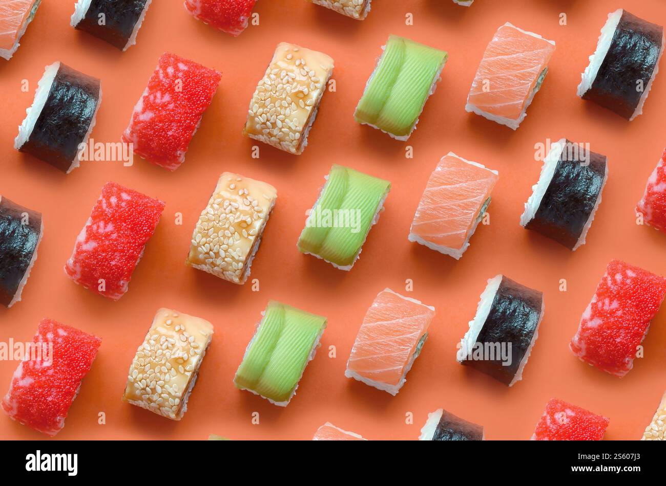 Different types of asian sushi rolls on orange background close up ...