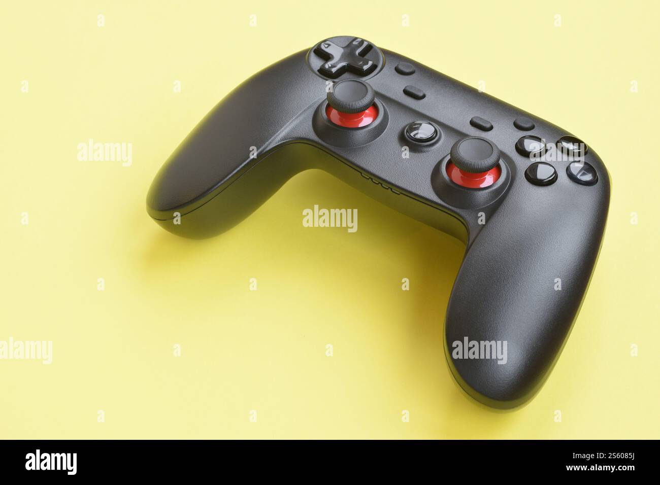 Modern black joystick on yellow background close up. Video game ...