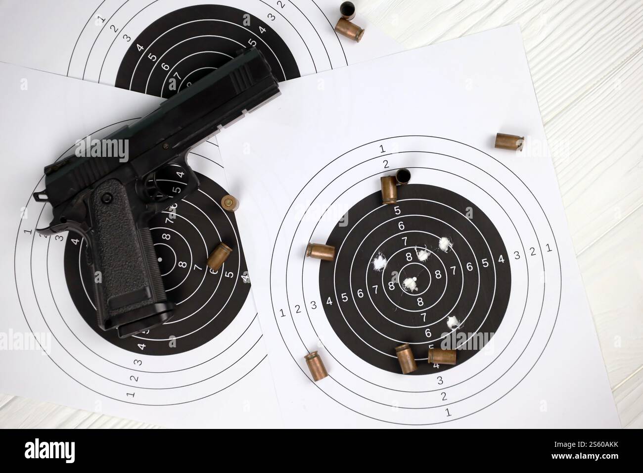 Gun and many bullets shooting targets on white table in shooting range ...