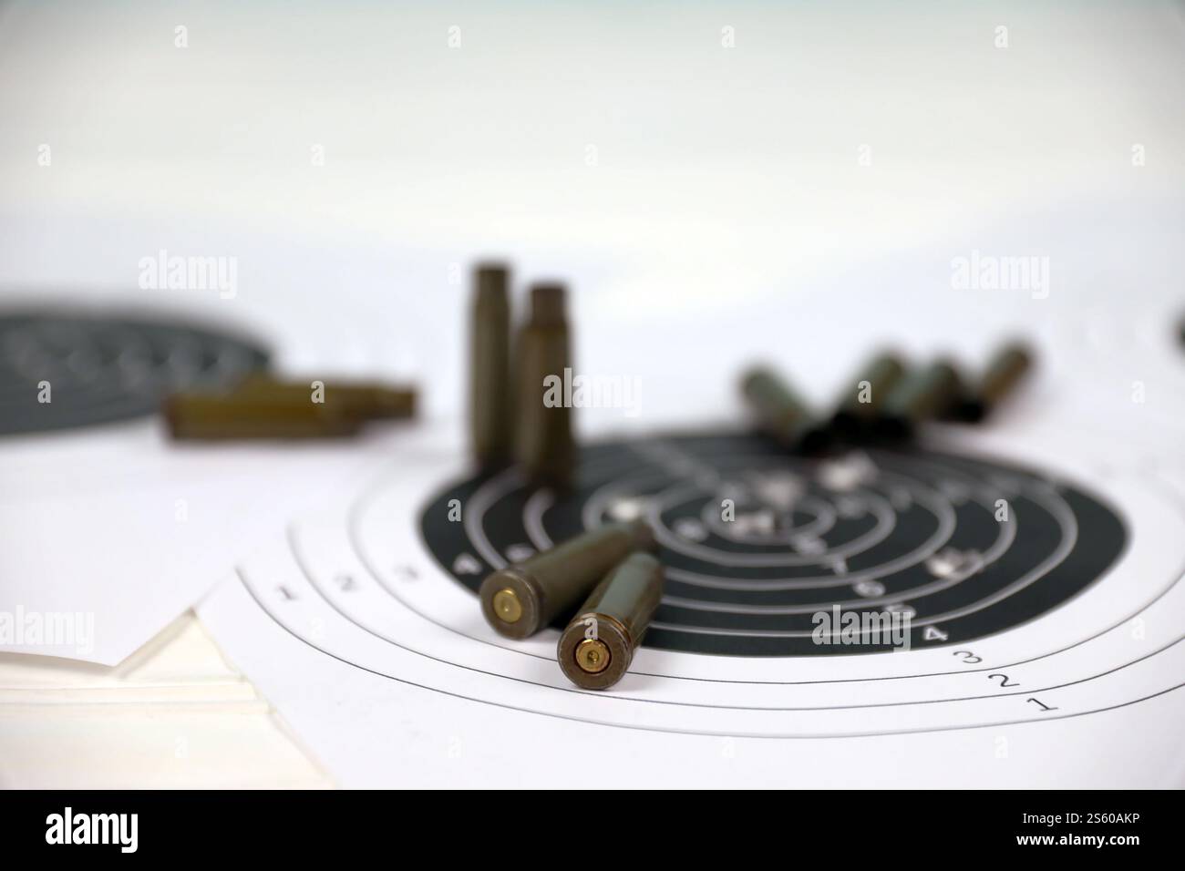 Many bullets with shooting targets on white table in shooting range ...