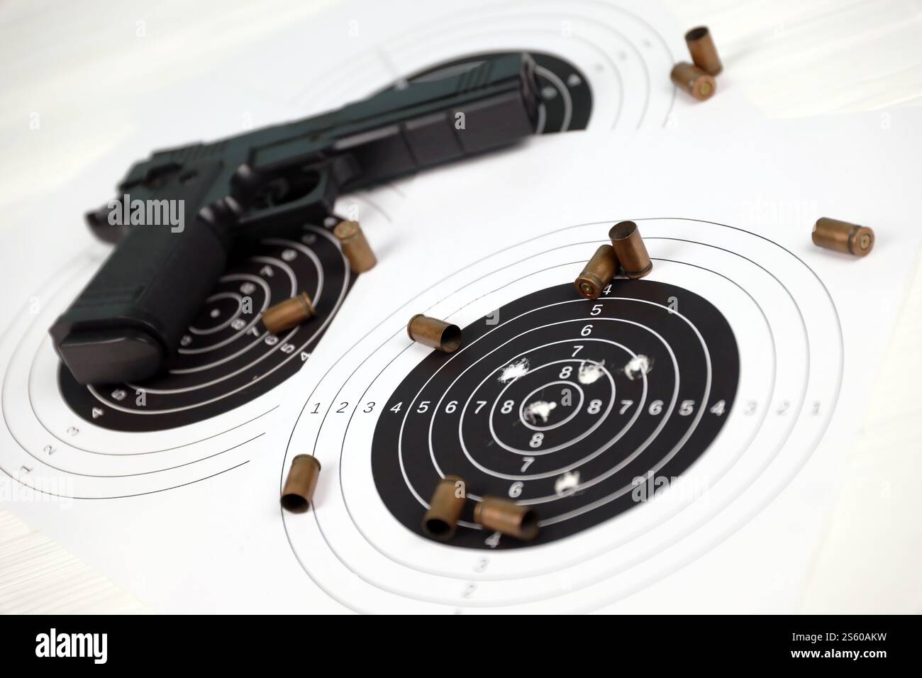 Gun and many bullets shooting targets on white table in shooting range ...
