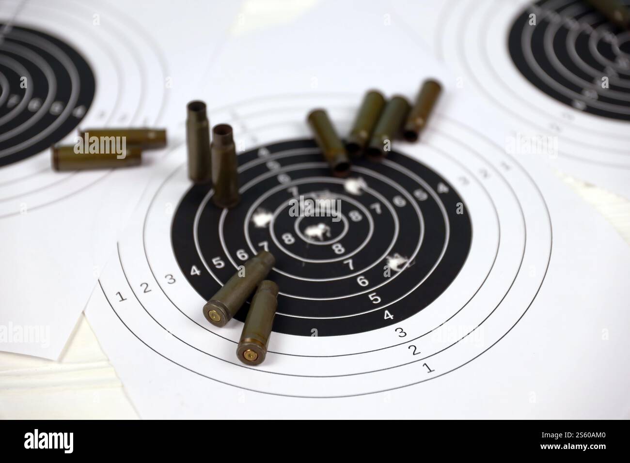 Many bullets with shooting targets on white table in shooting range ...