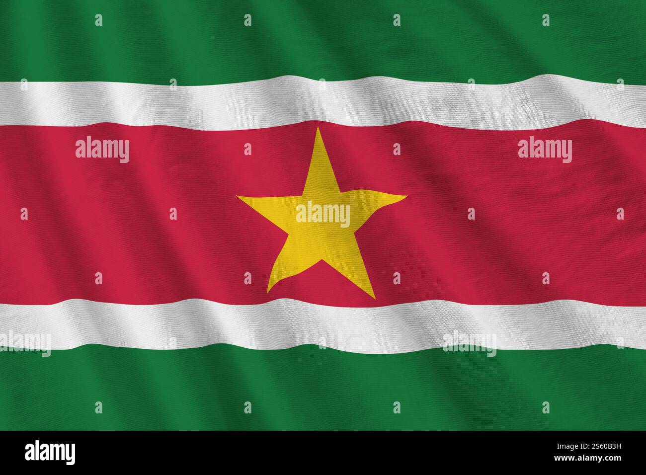 Suriname flag with big folds waving close up under the studio light ...