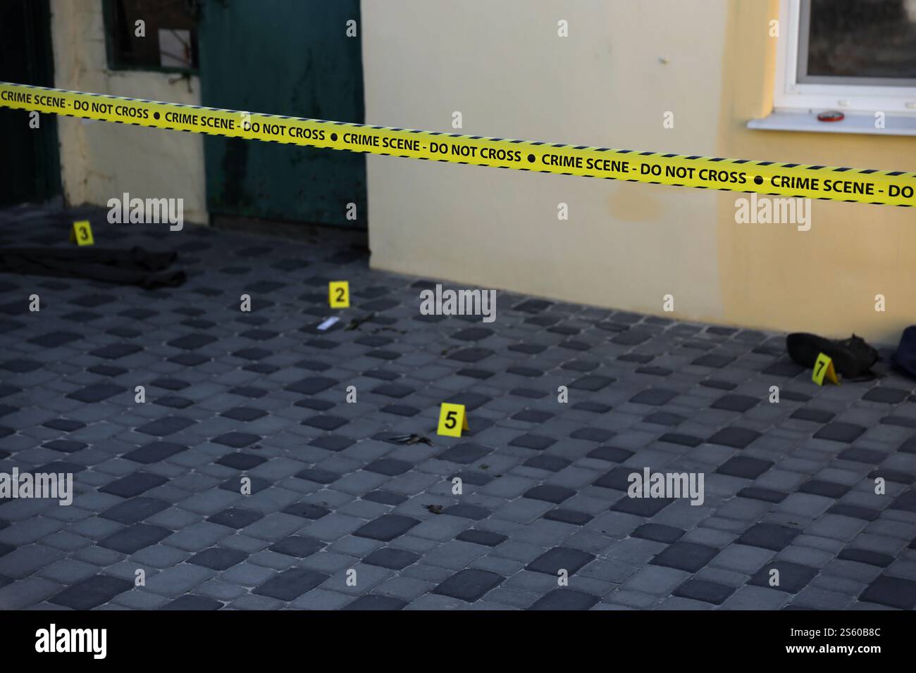 Crime scene tape for covering the area cordon. Yellow tape with blurred forensic law enforcement ...