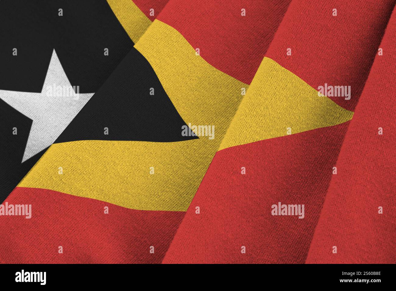 Timor Leste flag with big folds waving close up under the studio light ...