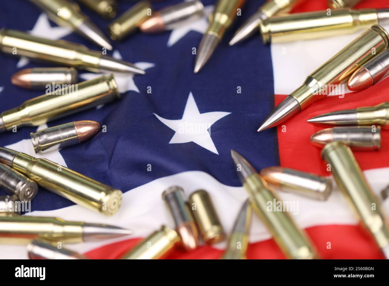 Many yellow 9mm and 5.56mm bullets and cartridges on United States flag ...