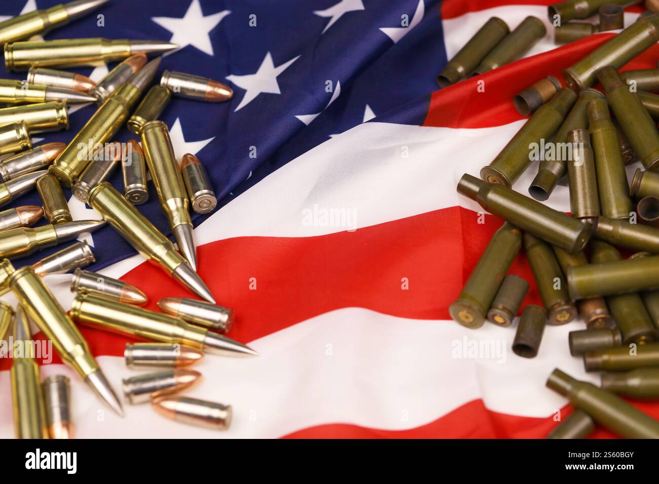 Many yellow 9mm and 5.56mm bullets and cartridges on United States flag ...