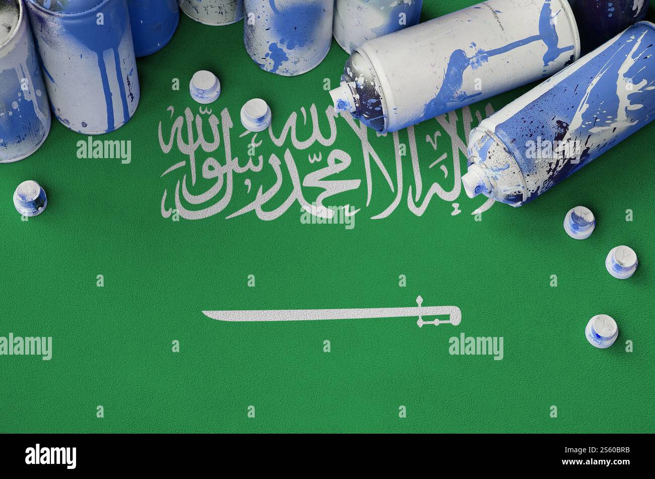 Saudi Arabia flag and few used aerosol spray cans for graffiti painting ...