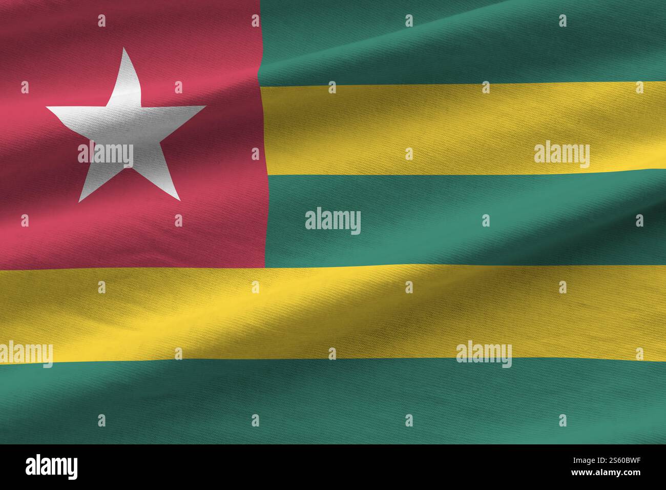 Togo flag with big folds waving close up under the studio light indoors ...