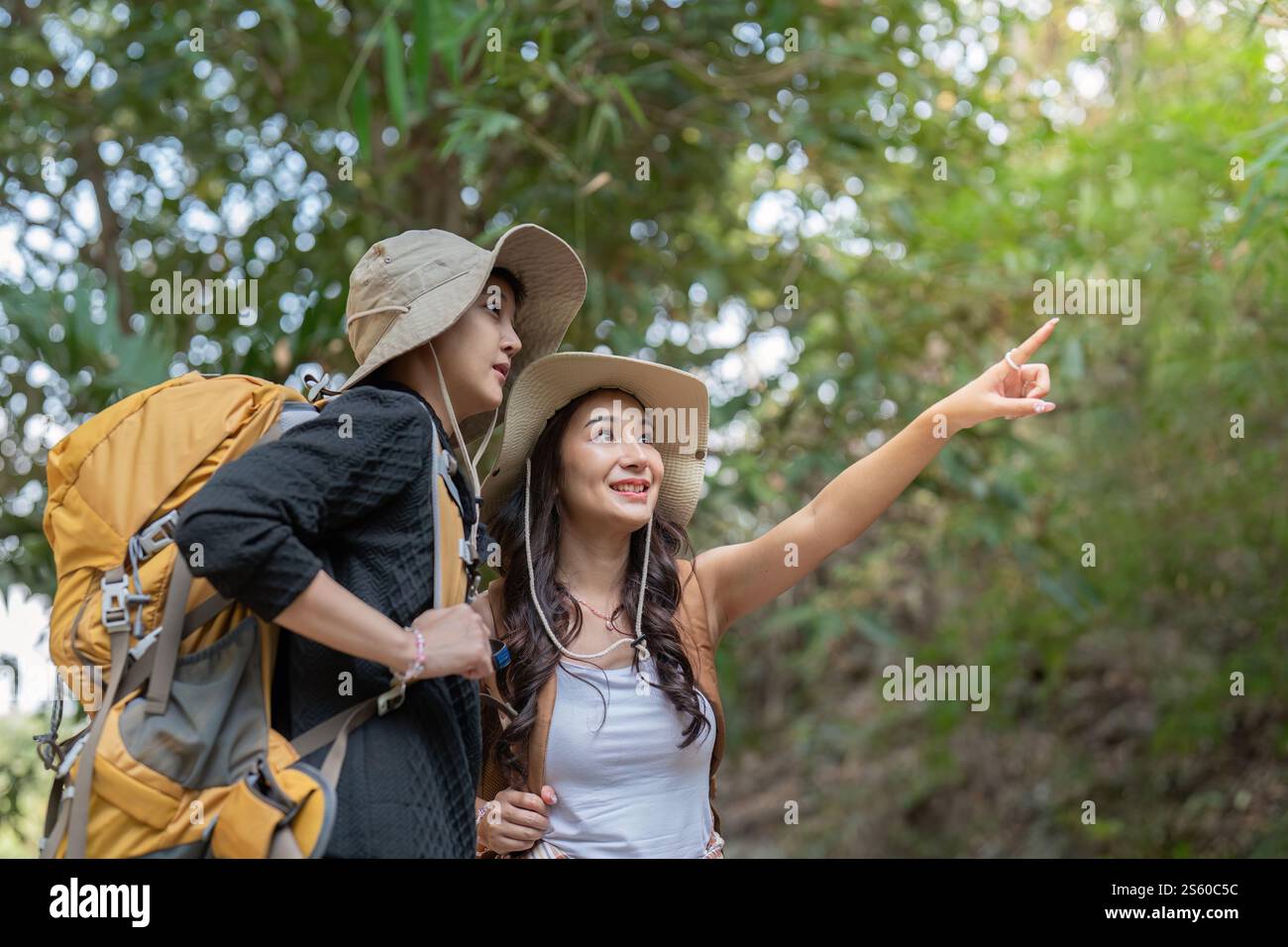 LGBT couple exploring nature, pointing out sights during their hiking ...