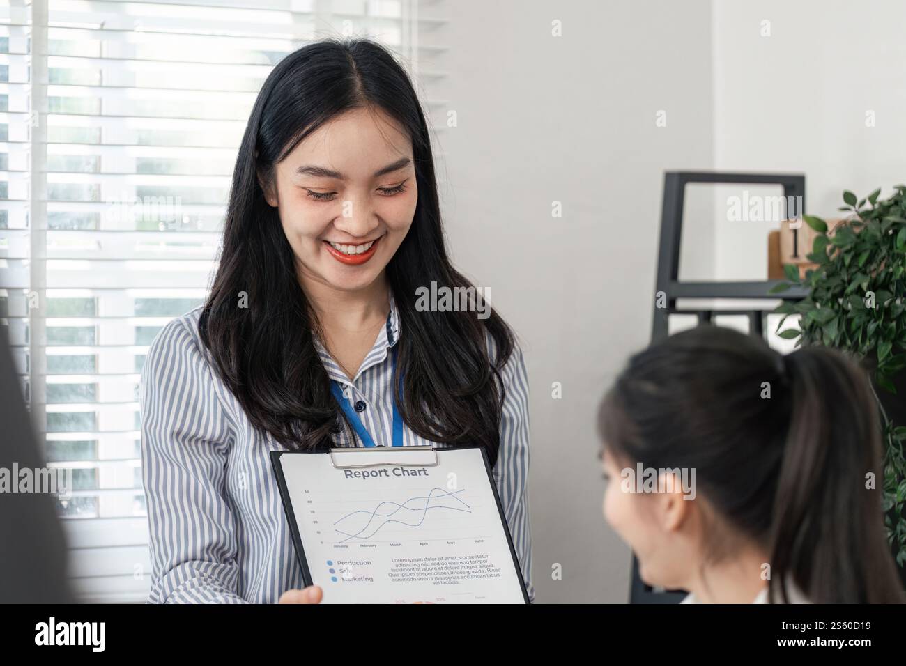 Business professional sharing a report chart with a colleague in an ...